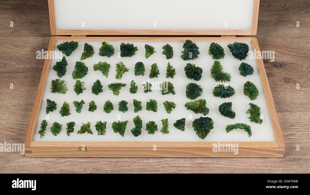 Collection of rare moldavite semi-precious stones in open wood casket ...