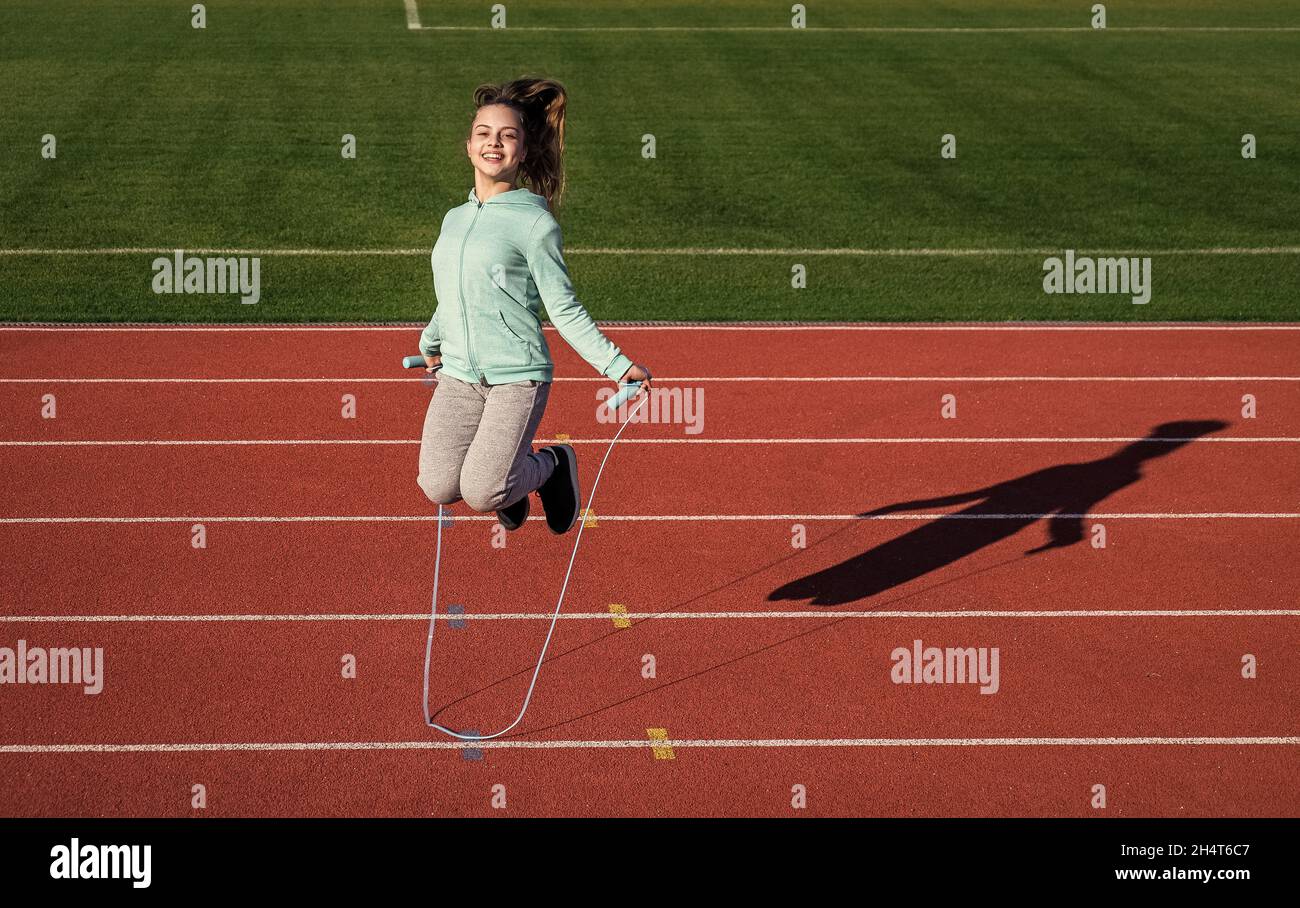 a workout routine. kid in sportswear jump on skipping rope. child do ...
