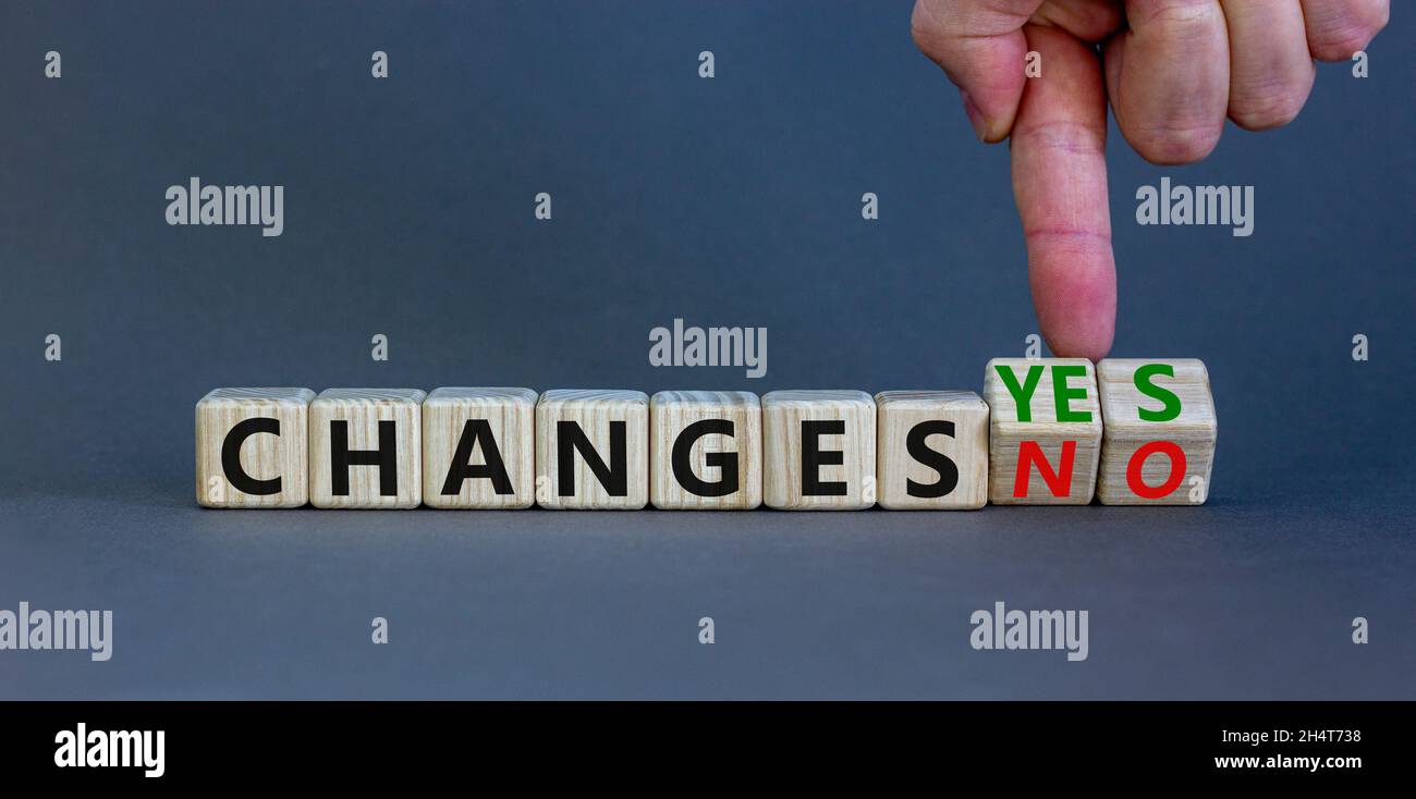 Changes yes or no symbol. Businessman turns wooden cubes and changs ...