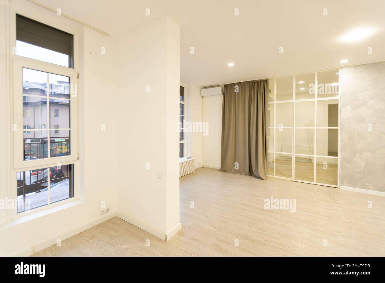 Modern white loft room with big windows and city view Stock Photo - Alamy
