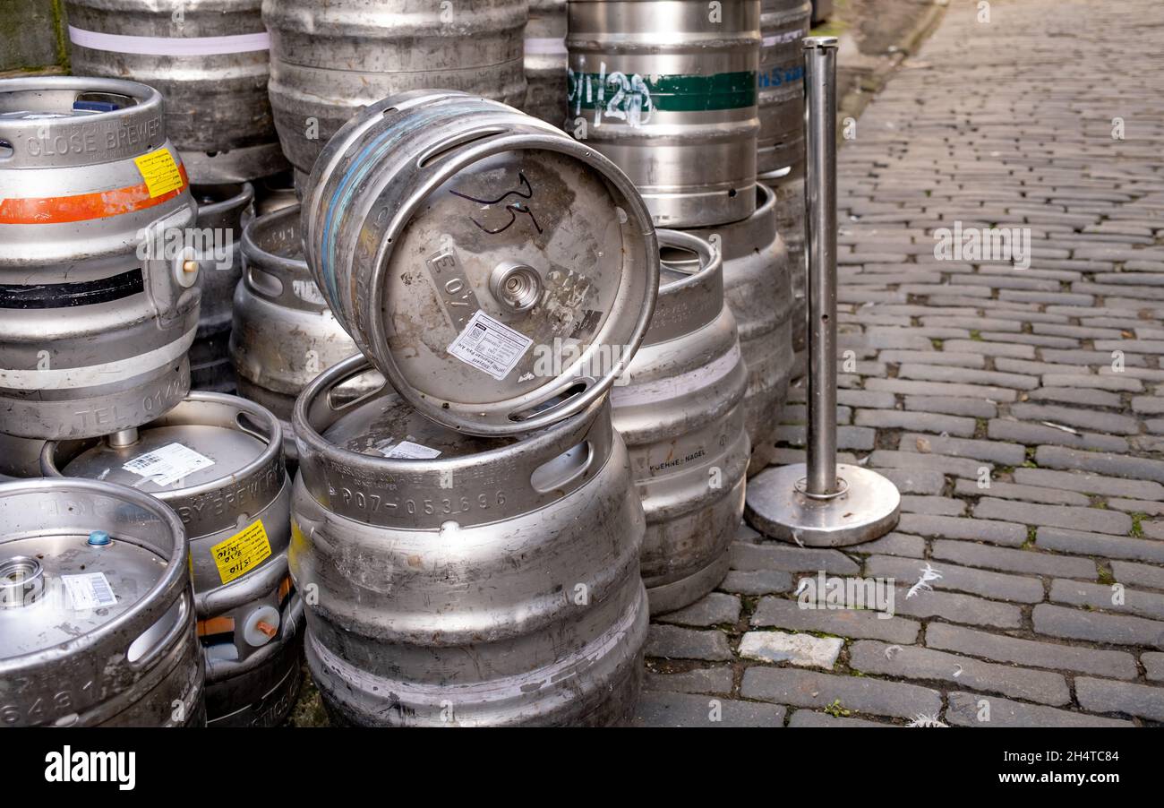 Close up of metal beer kegs stacked up outside a pub ready for ...