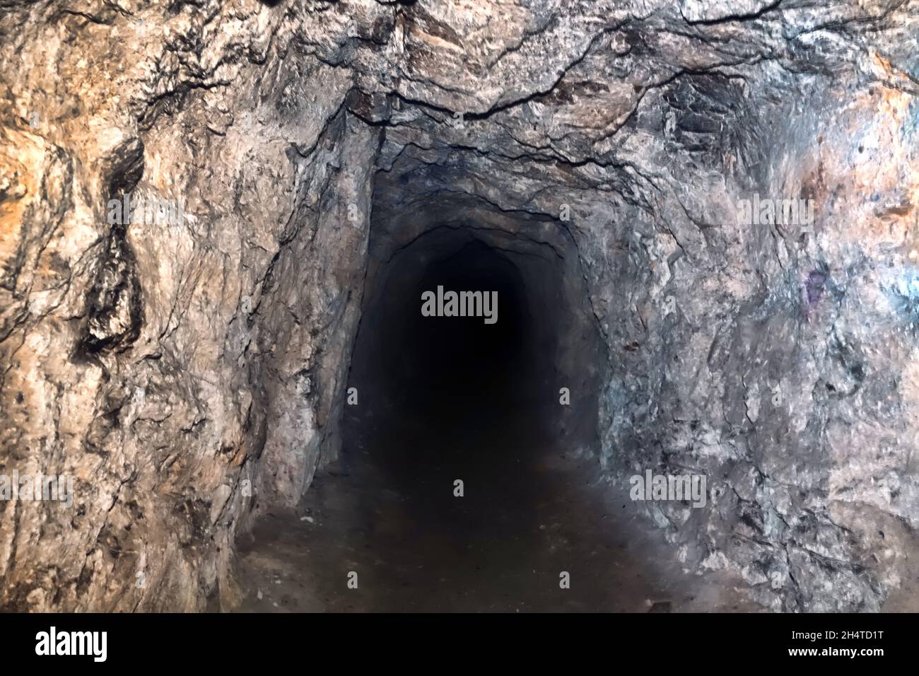 An old flooded mine, an underground corridor, and walls covered with ...