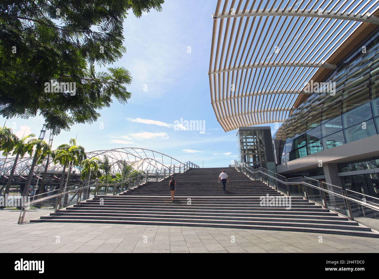 Two people climbing the steps to the Helix Bridge outside The Shoppes ...