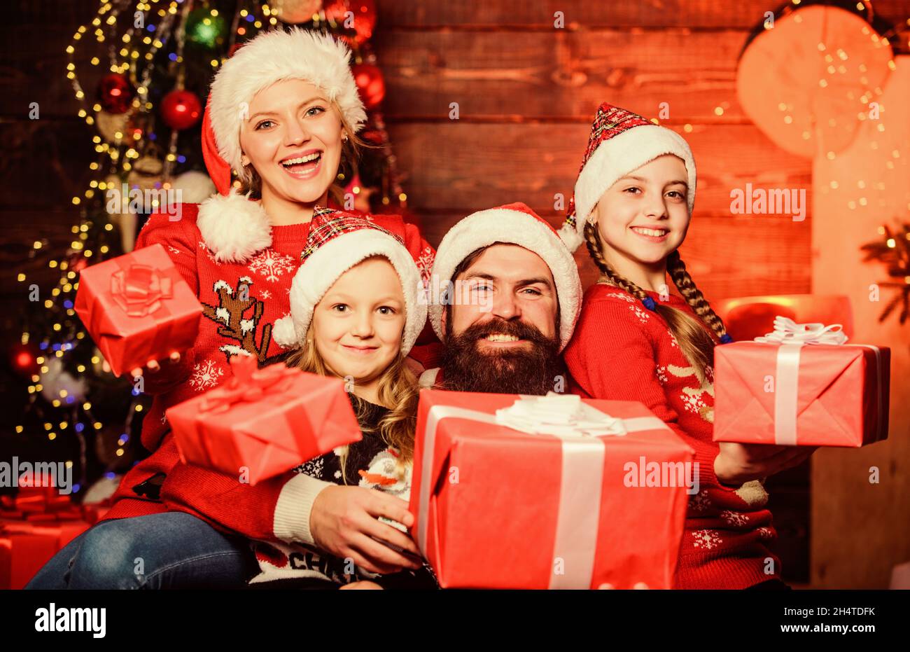 Parents and children opening christmas gifts. Father Santa claus and ...