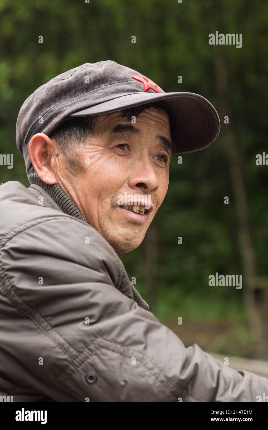 An older Chinese man in a red star cap poses in Zhangjiajie National ...