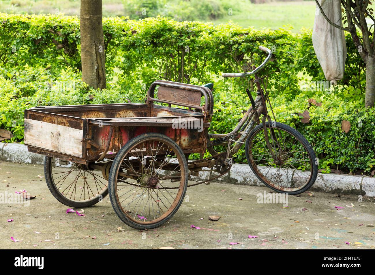 A three-wheeled tricycle cart parked along a street in Yangshuo, China ...