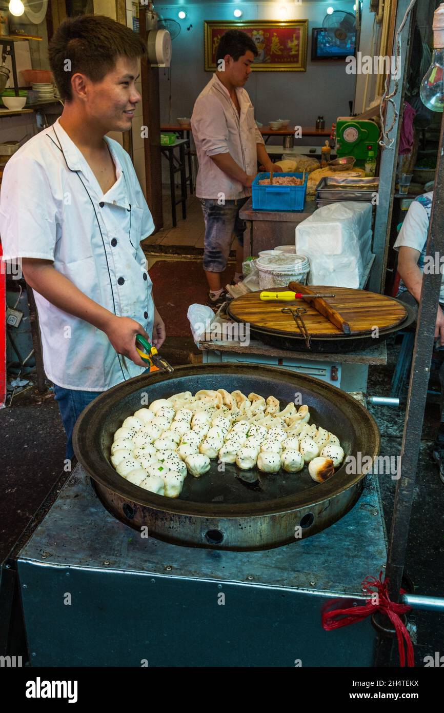 A Young Man Cooks Dumplings In An Outdoor Kitchen In The Street Market