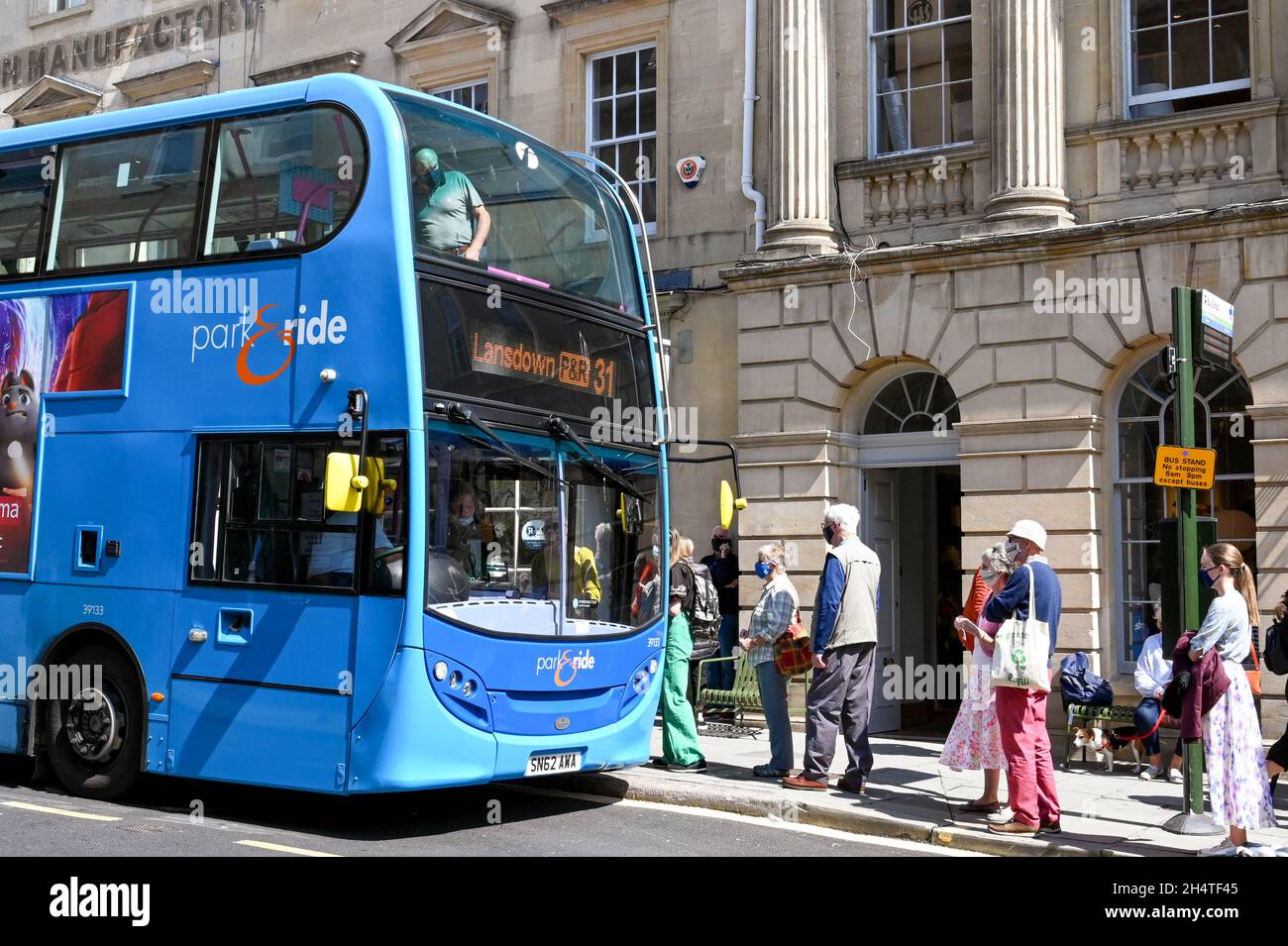 Bath, England - August 2021: People queuing to get on a public service ...