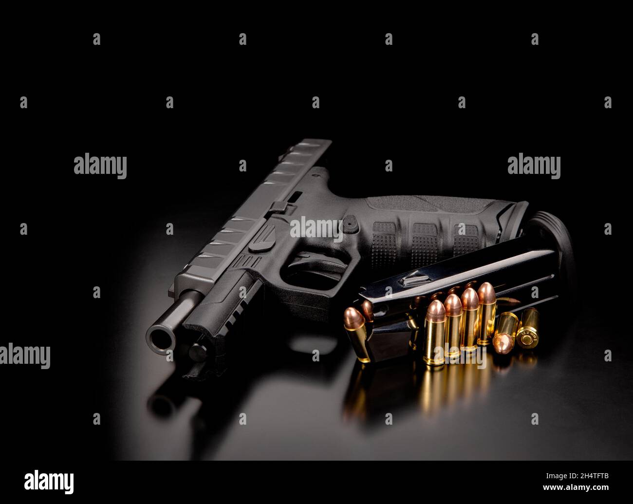 Discharged weapon. Black modern gun and ammunition for it on a dark ...