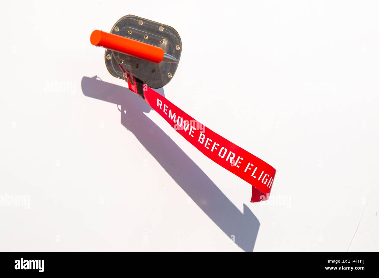 red ribbon remove before flight on an airplane Stock Photo - Alamy