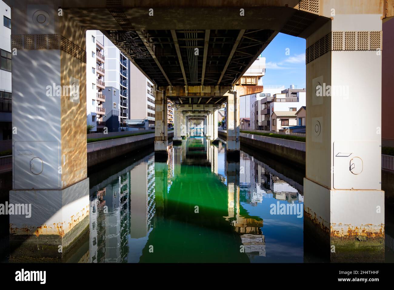 The underside of freeway over a canal that flows through suburban ...