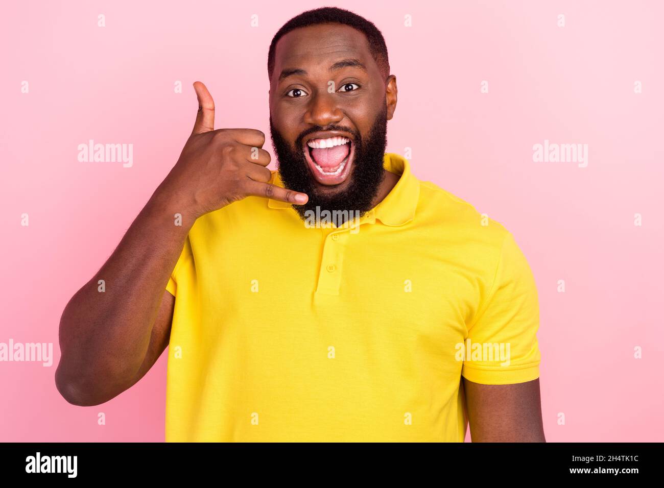 Portrait of attractive cheerful virile guy showing call me sign ...