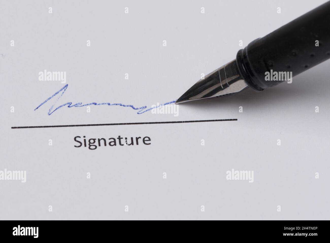 Close up of fountain pen on white paper with signature on signatures ...