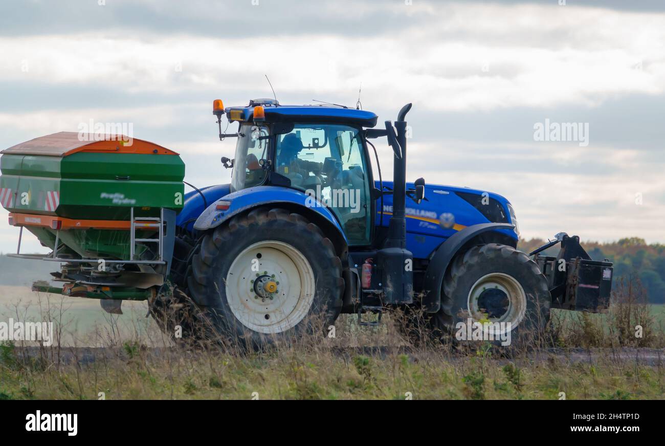 large blue New Holland T7 225 tractor in action with a mounted Amazone ...