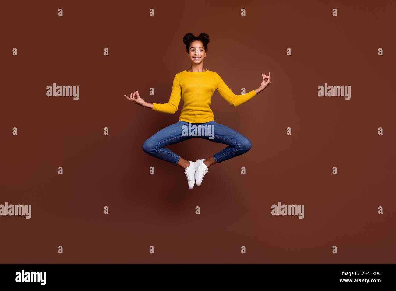 Full length photo of teen girl jump do asana wear shirt jeans sneakers ...