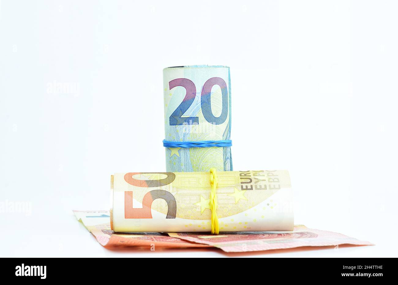 Rolls of Euro banknotes in a glass jar isolated on a white background ...