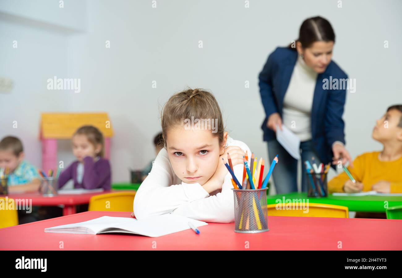 Sad schoolgirl in classroom during lesson Stock Photo - Alamy