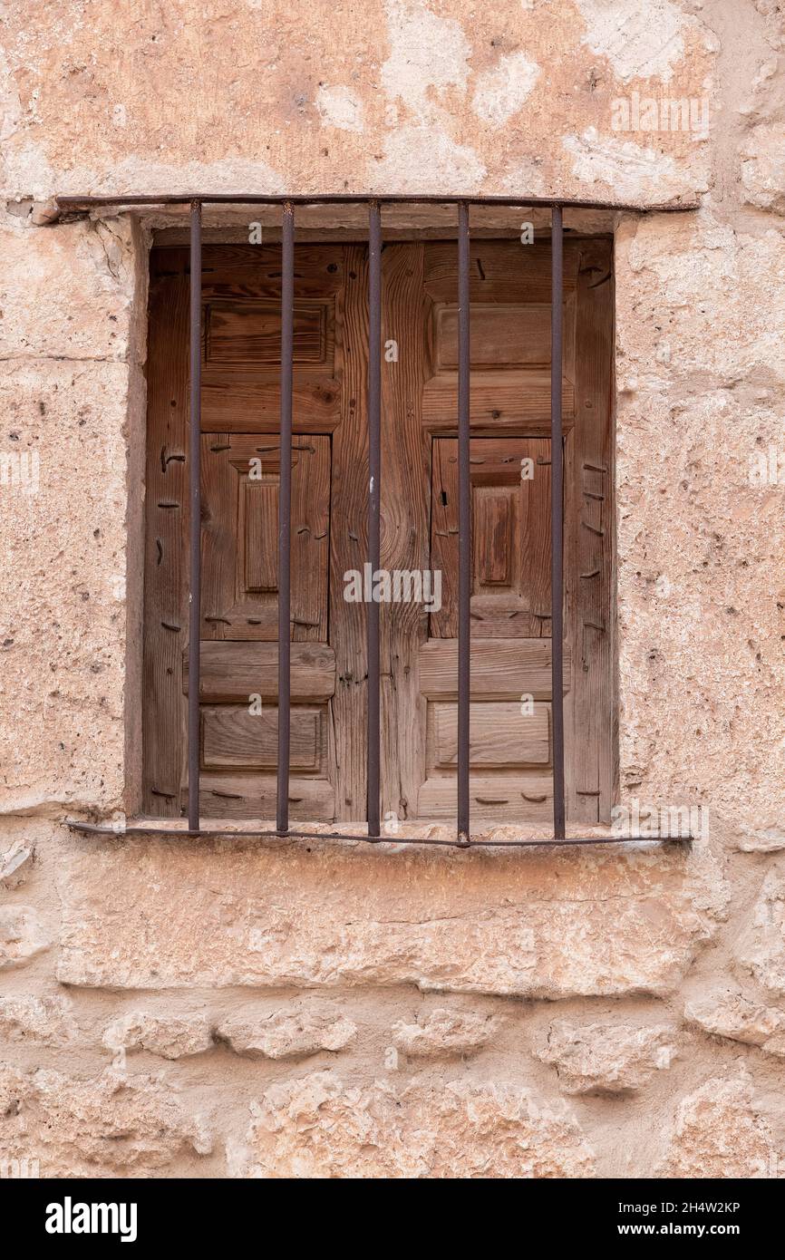 Old wooden window with rusty bars in the stone walls of a village Stock ...