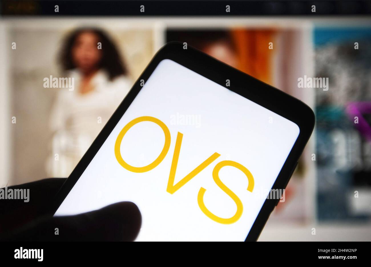 In this photo illustration an OVS logo is seen on a smartphone screen in front of its website ...