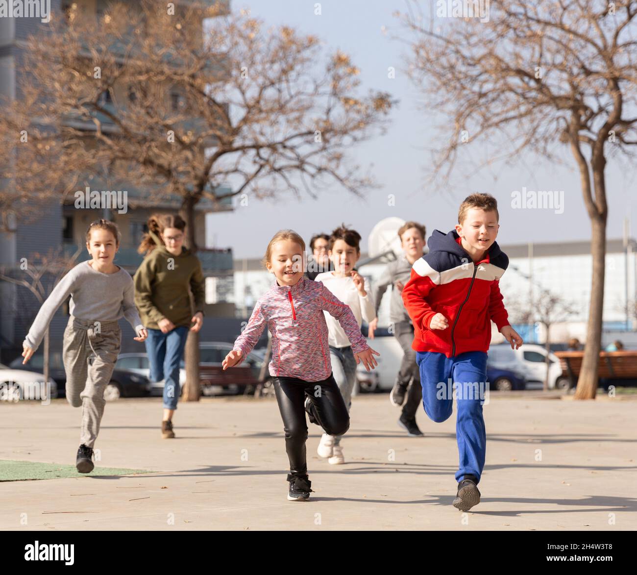 Group of joyful children running down the city street Stock Photo - Alamy