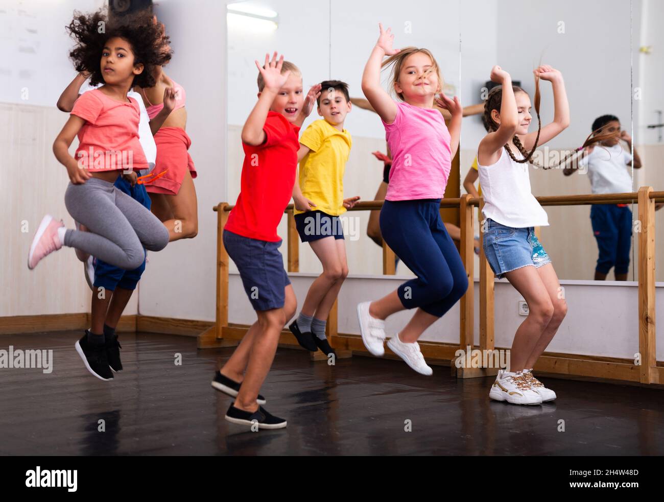Cheerful preteen boys and girls jumping in dance class Stock Photo - Alamy