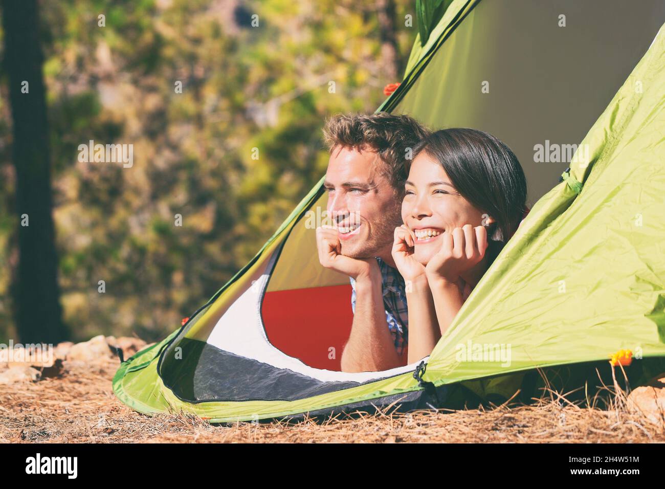 Two young people relaxing in camping tent in summer outdoors nature ...