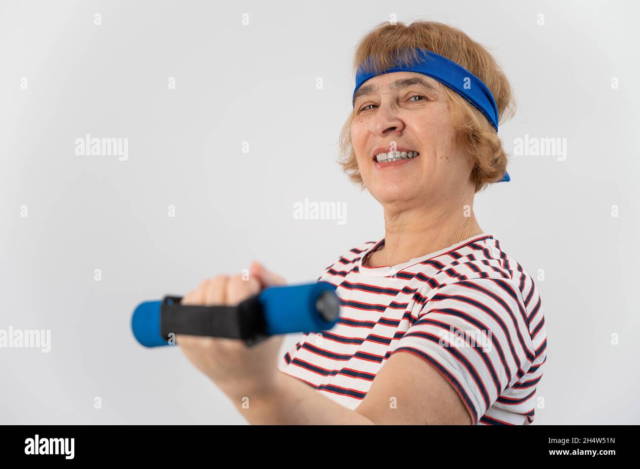 Happy old woman doing fitness exercises with dumbbells on a white ...