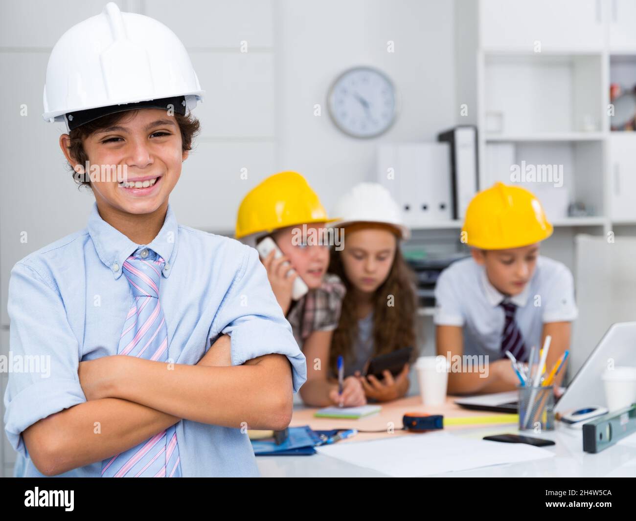 Teenager boy engineer and children with plan Stock Photo - Alamy