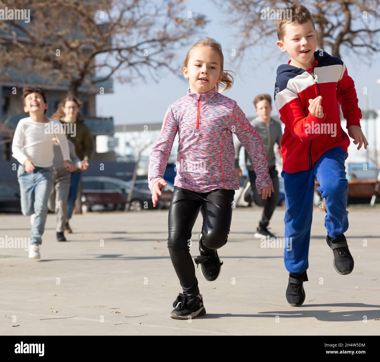Happy children running on city street Stock Photo - Alamy