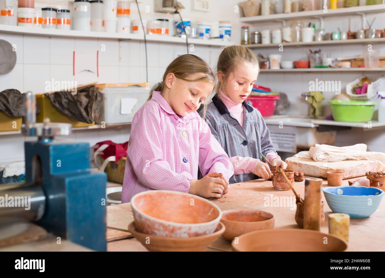 Smiling schoolgirls training to make ceramics during arts Stock Photo ...