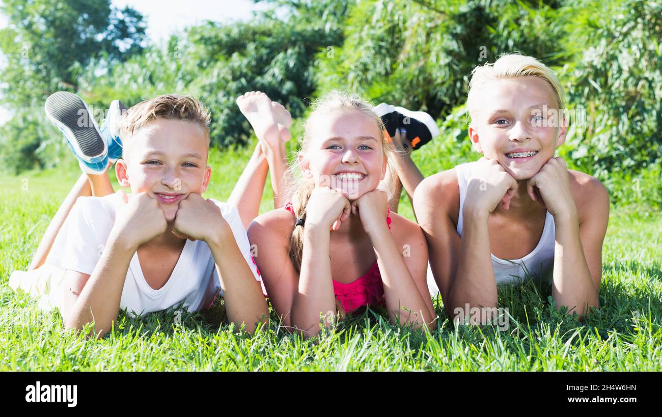 Happy kids laying on grass Stock Photo - Alamy
