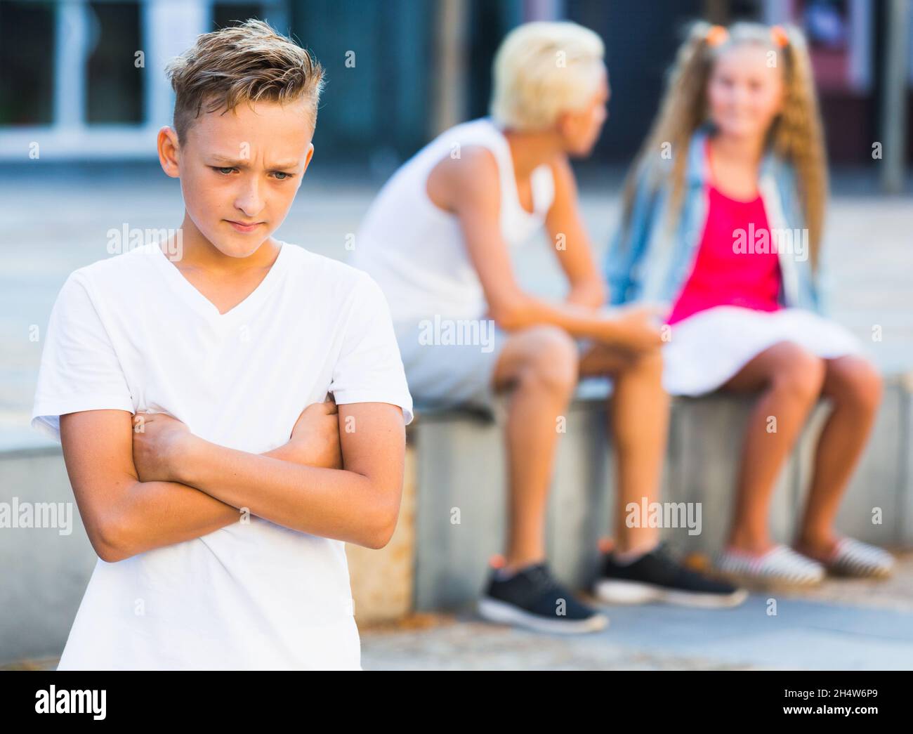 Sad boy having problems with friends Stock Photo - Alamy