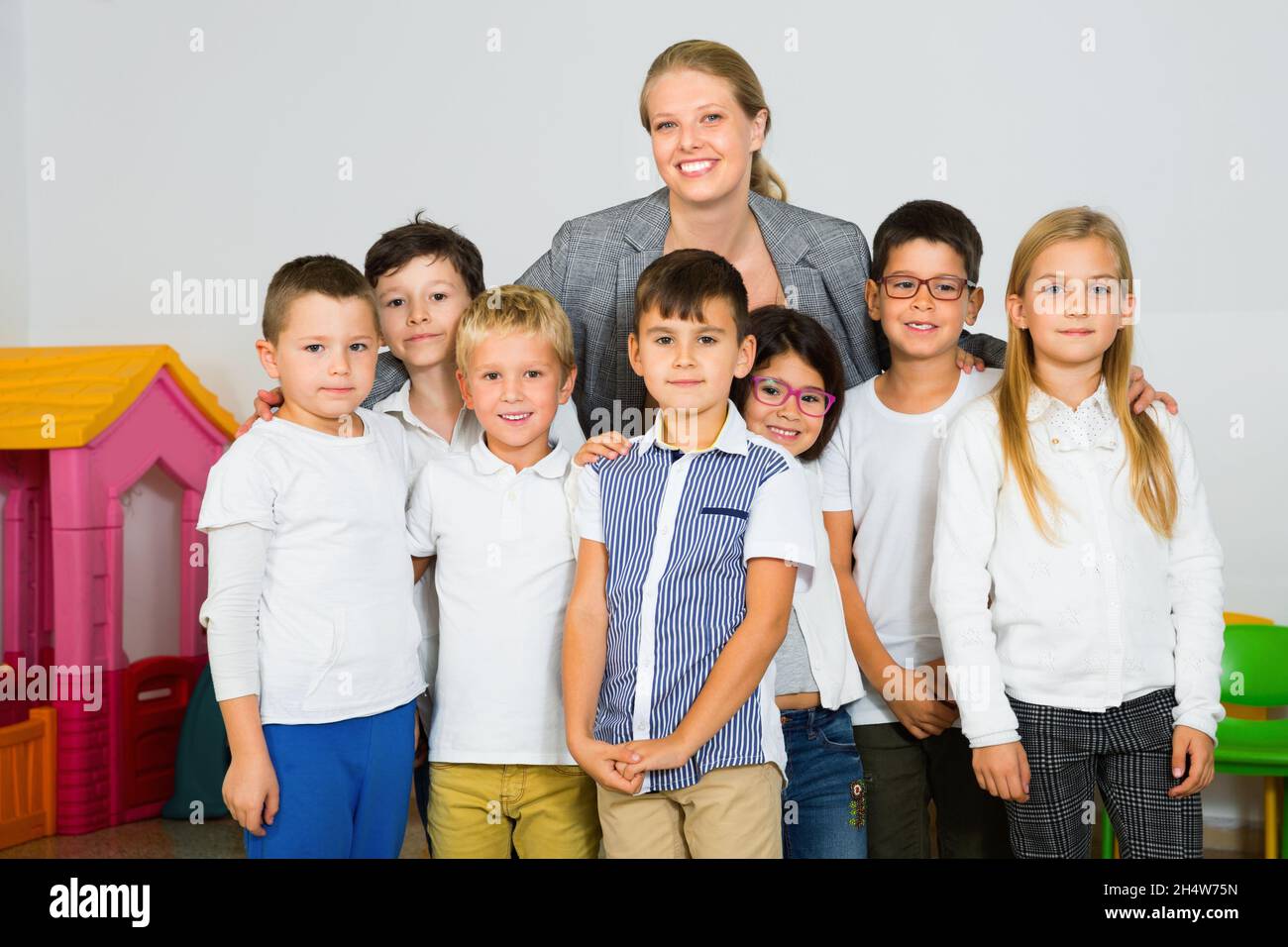 Portrait of cheerful female teacher with her happy schoolkids in ...