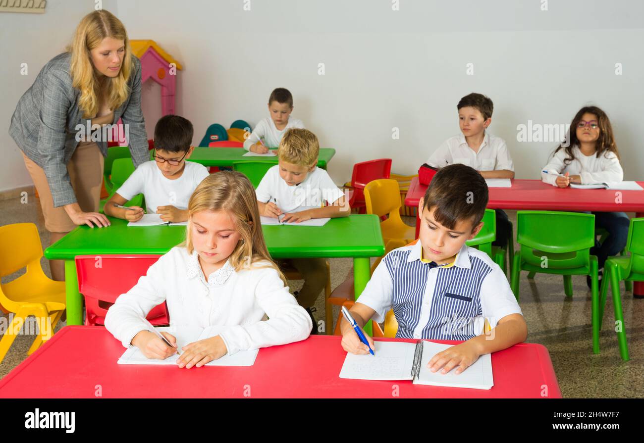 School kids studying in classroom with teacher Stock Photo - Alamy