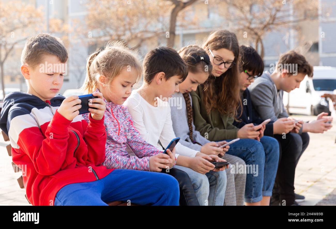 Children are playing on smartphone in the playground Stock Photo - Alamy