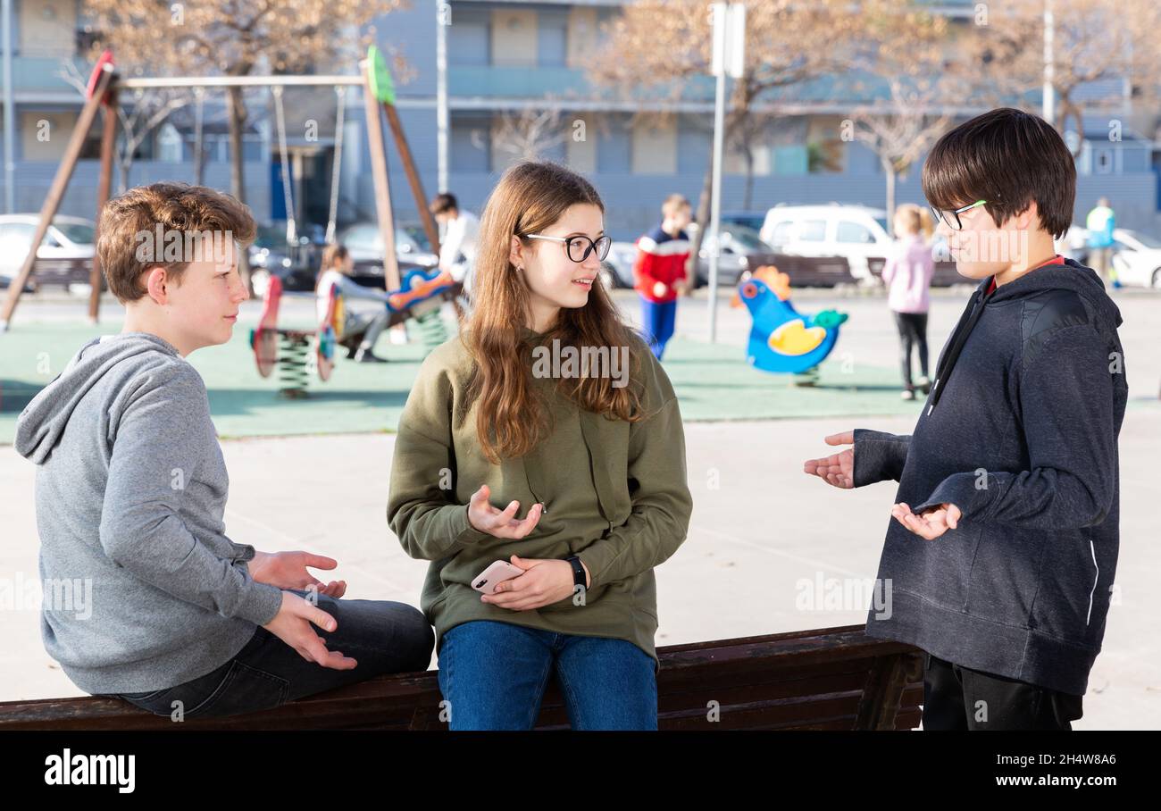 Children talking on bench on playground Stock Photo - Alamy