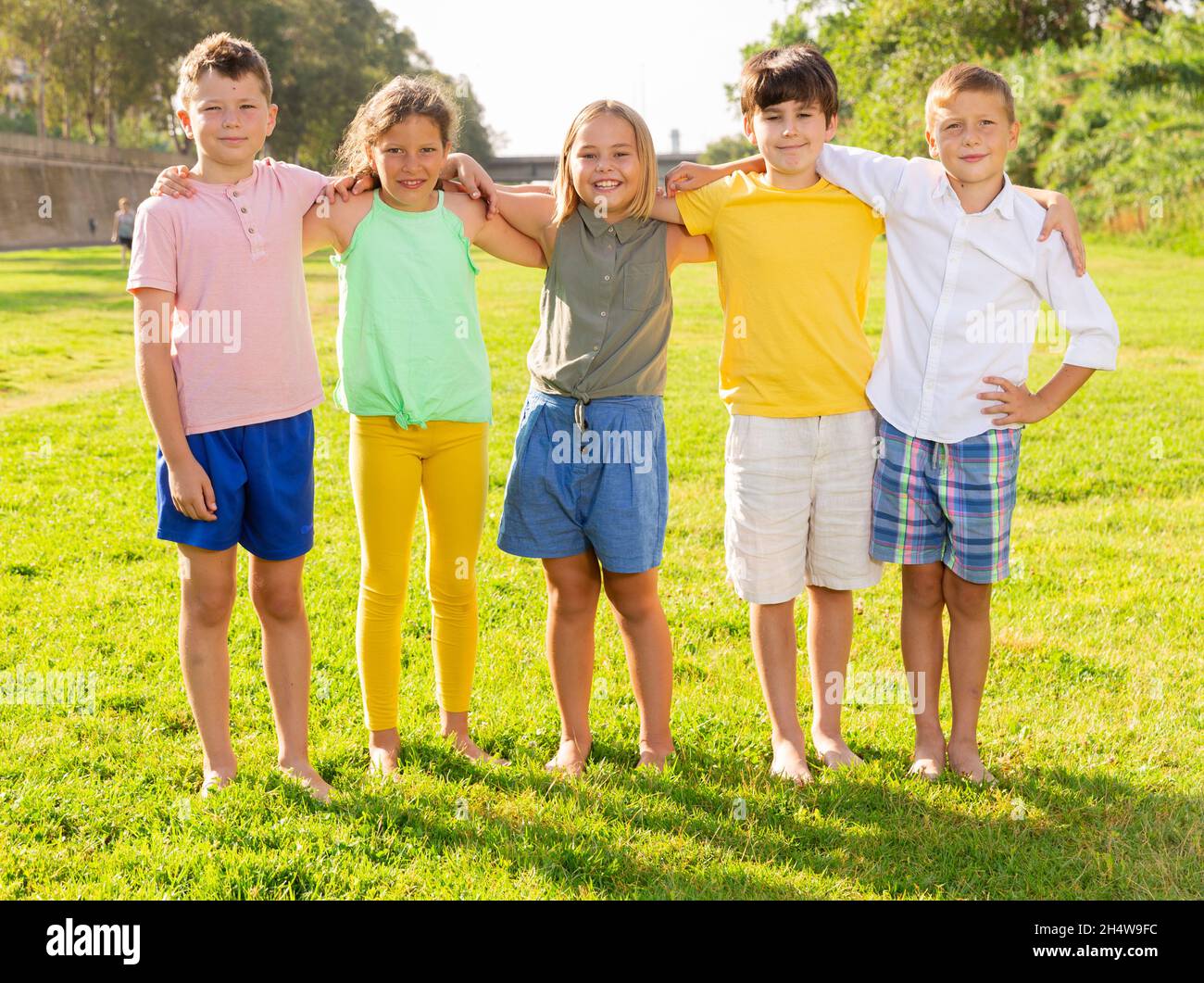 Portrait of five glad children who are walking and posing in park Stock ...