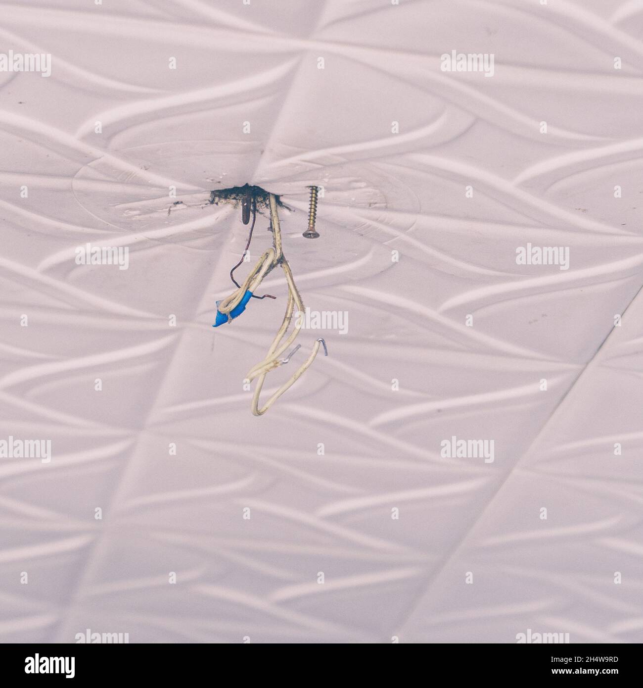Dangerous bad wiring which hangs on the ceiling Stock Photo - Alamy