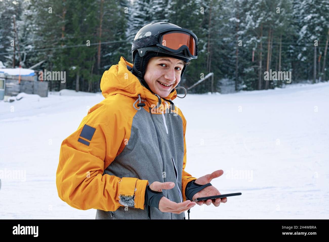 Portrait attractive happy smiling snowboarder with smartphone. A ...