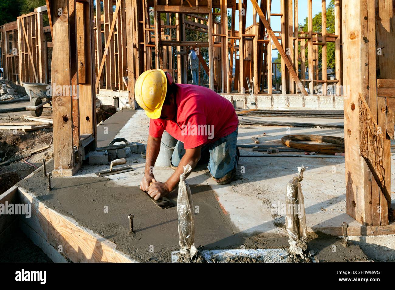 Concrete Mason finishing a concrete patch on an existing slab on grade ...