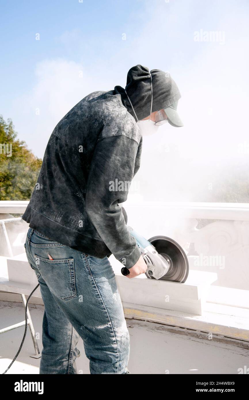 Stone mason cutting marble slab with a high speed angle grinder Stock ...