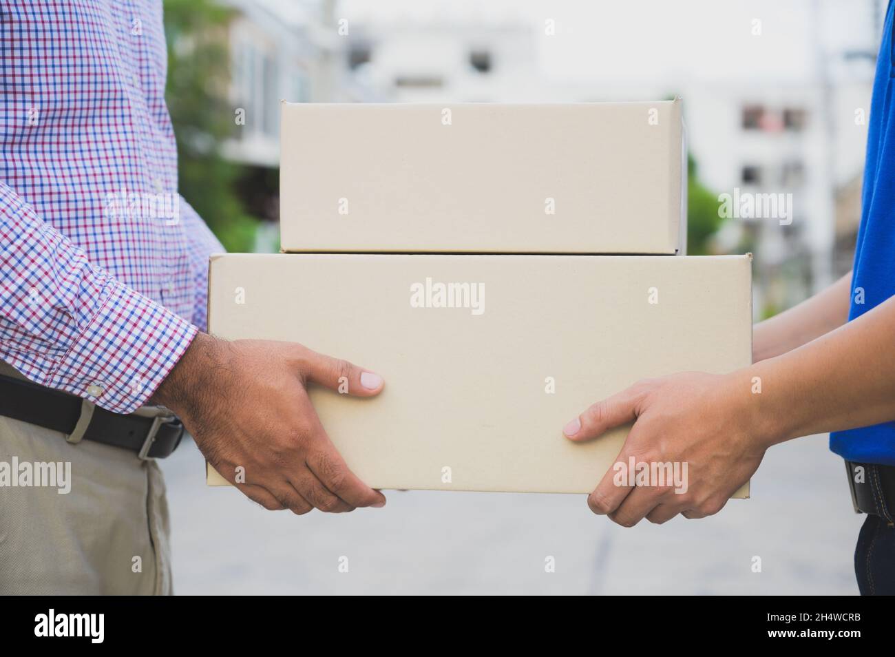 Hand accepting a delivery of boxes from deliveryman Stock Photo - Alamy