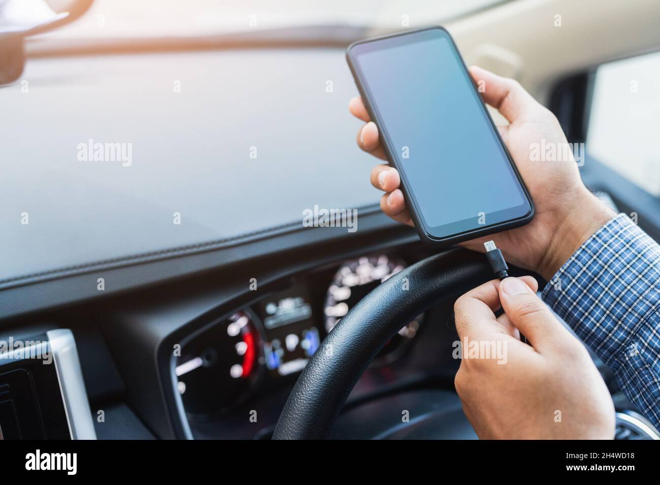 Hands man holding and charging battery mobile smartphone in car with ...