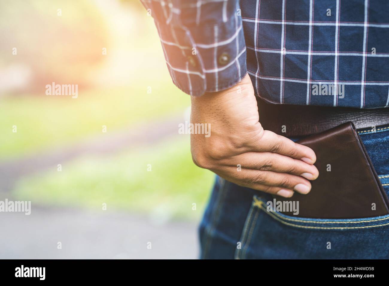 Man putting his wallet in back pocket Stock Photo - Alamy