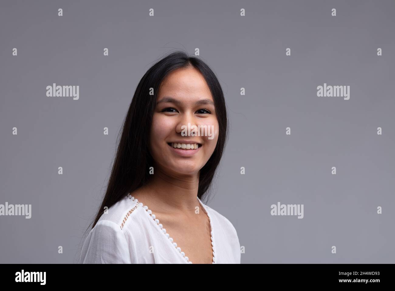 Happy young woman with a genuine warm friendly smile in a head and ...