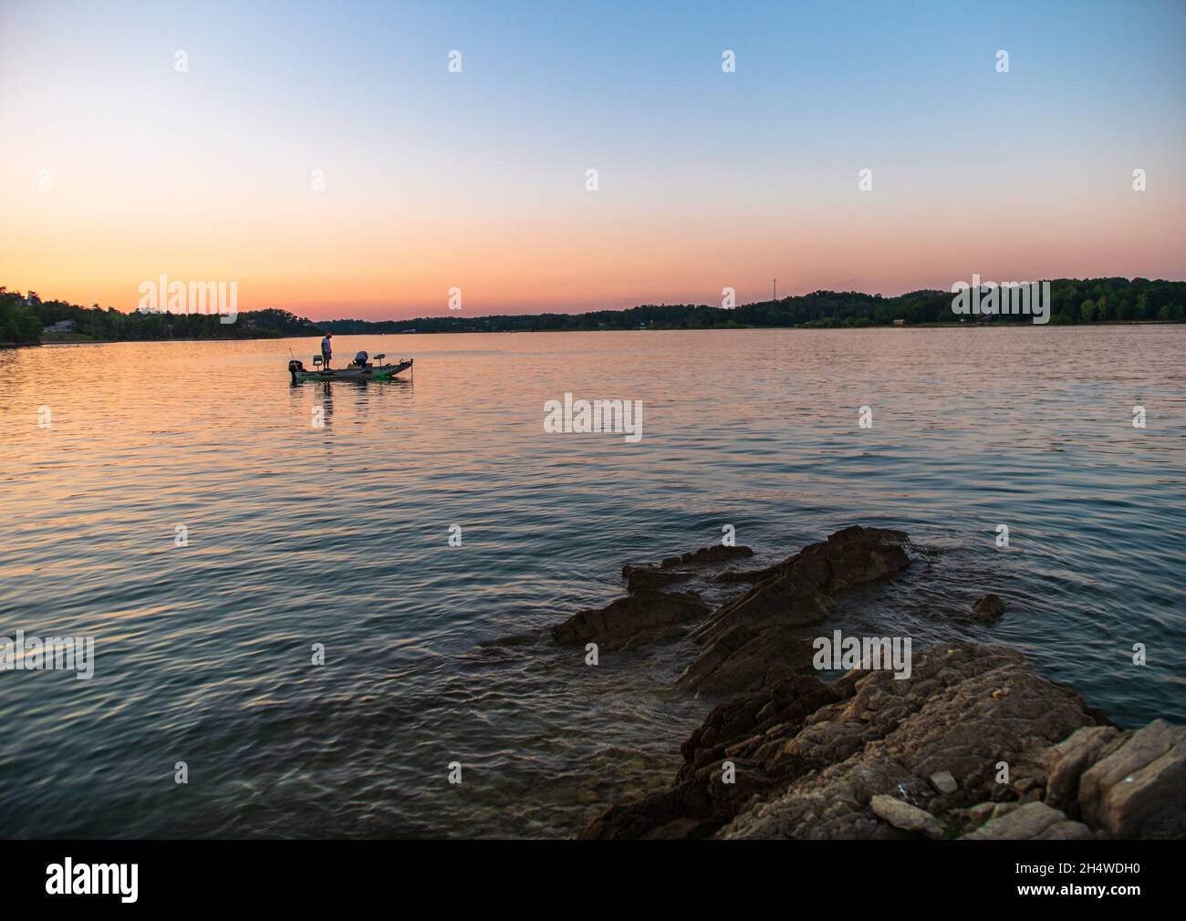 Scenic view of people on the boat sailing in the lake on a sunset ...