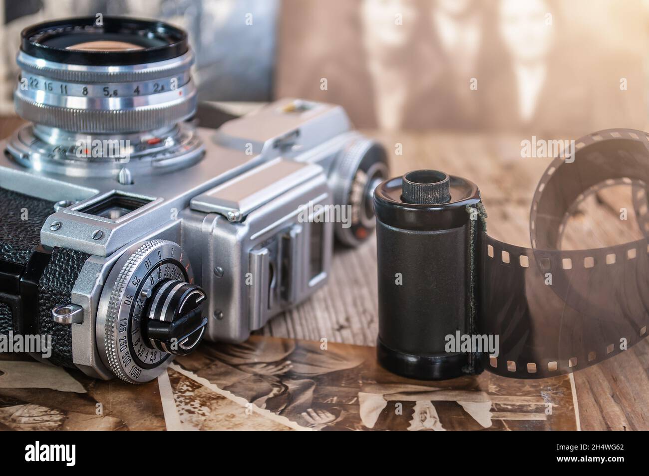 still life with retro analog camera, camera roll and old photos on wood ...