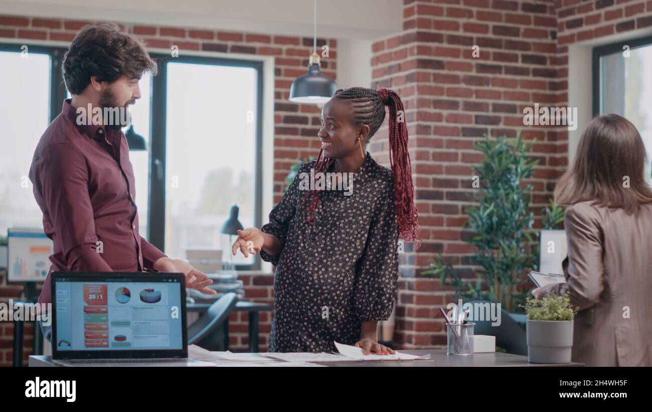 Multi ethnic team of people giving highfive while working on business ...