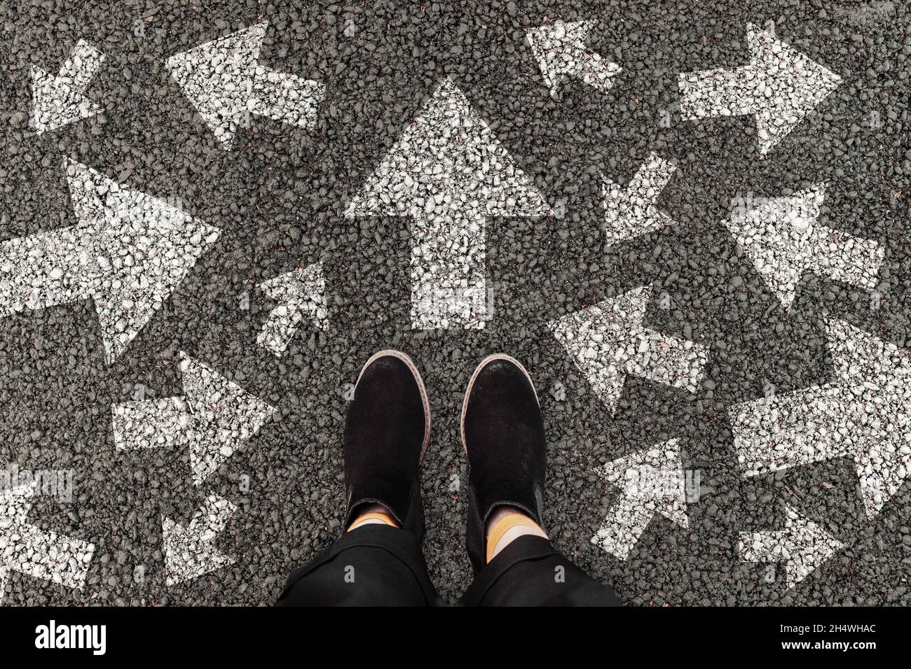 Person standing on road with arrow markings pointing in different ...