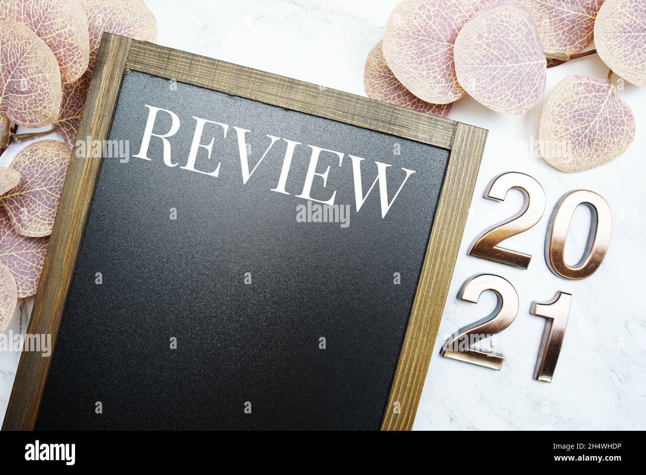 Review 2021 with space copy on blackboard with eucalyptus leaves on ...
